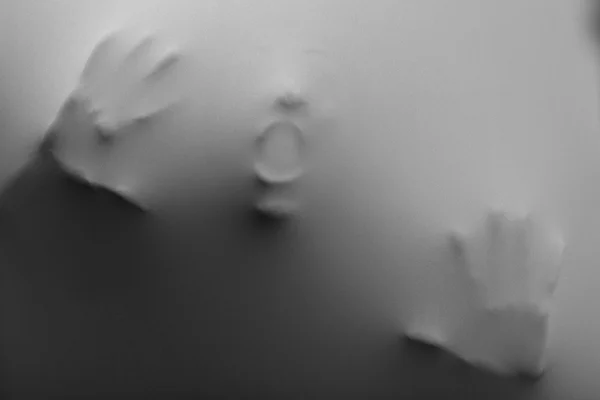 Screaming human face with hands pressing through fabric as horror ...