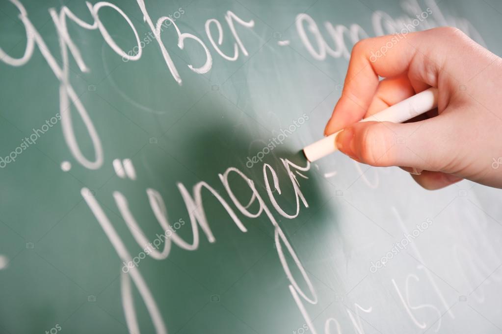 Profesor mano escritura gramática oraciones en pizarra fondo 2024