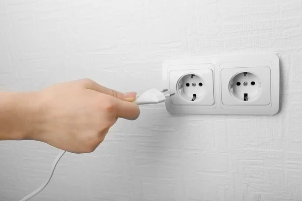 Hand putting plug in electricity socket close up Stock Photo by ...