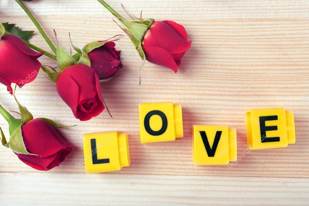 Beautiful roses with word LOVE on wooden background — Stock Photo ...