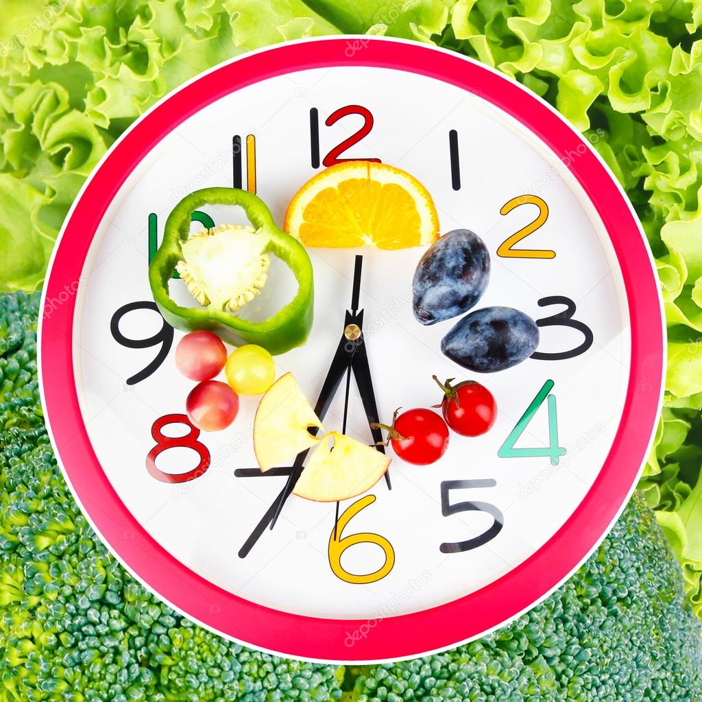 Reloj de alimentos con verduras y frutas como fondo. Concepto de comida ...