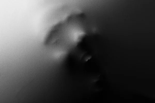 Screaming human face with hands pressing through fabric as horror ...