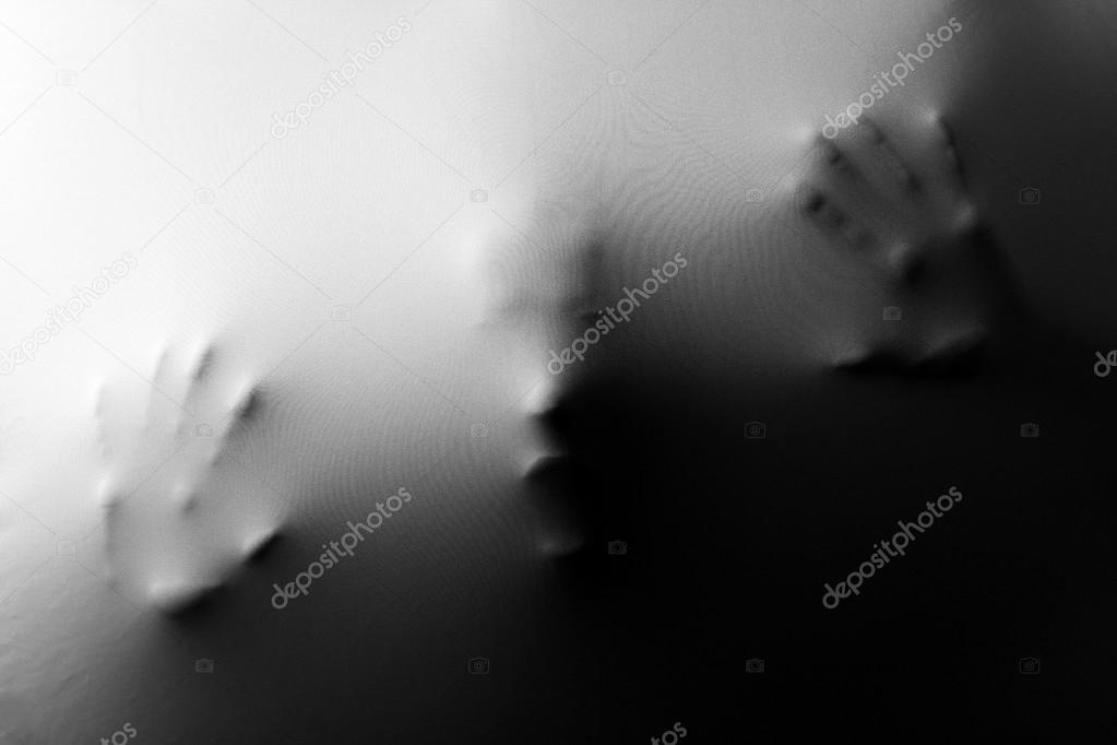 Screaming human face with hands pressing through fabric as horror ...