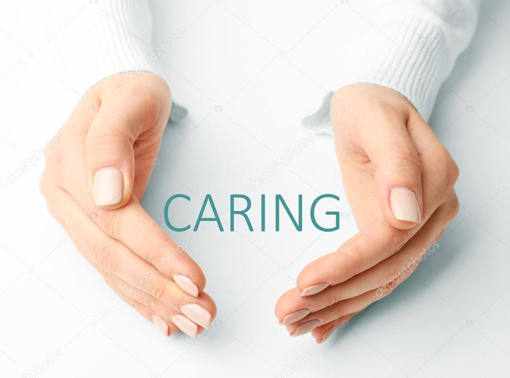 Female hands with word caring on light background Stock Photo by ...