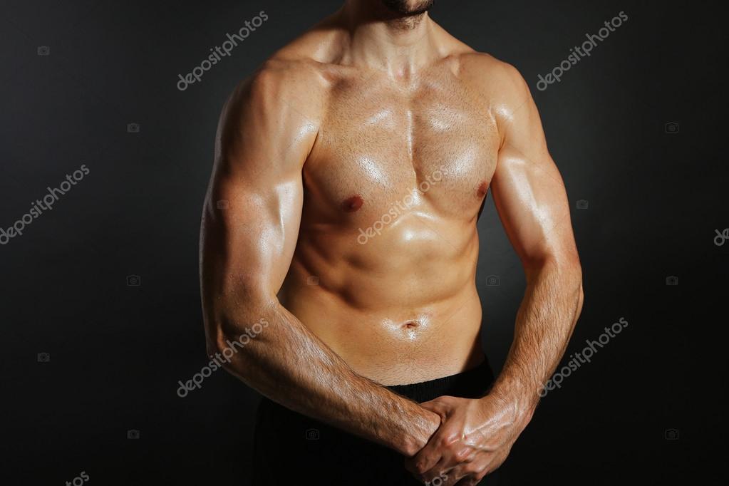 Muscle young man on dark background Stock Photo by ©belchonock 71949229