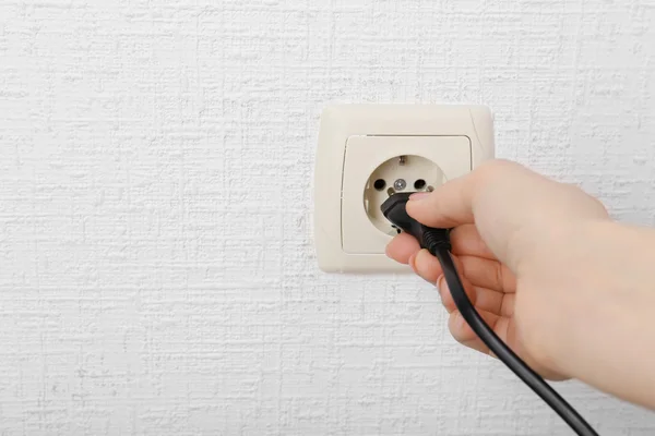 Hand putting plug in electricity socket - Stock Image - Everypixel