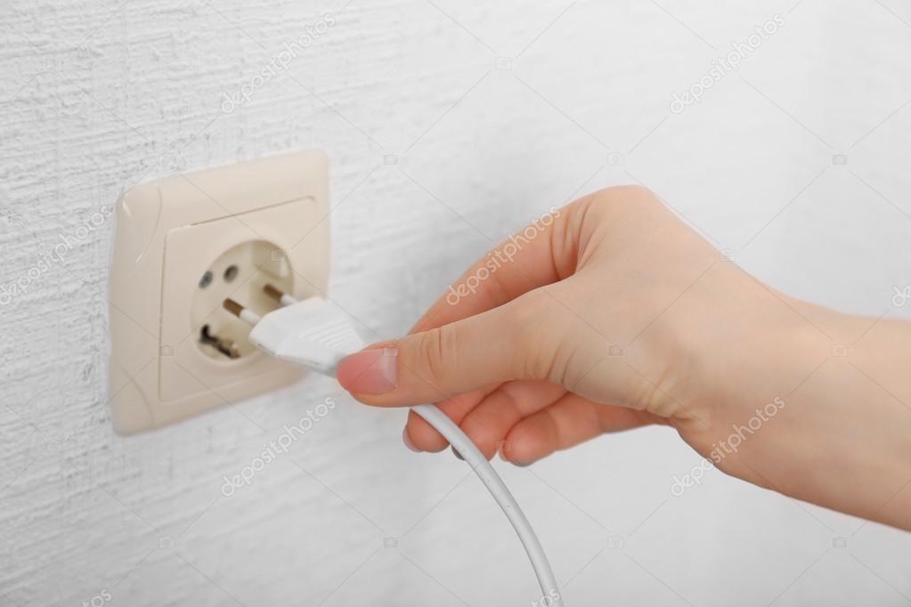 Hand putting plug in electricity socket close up Stock Photo by ...