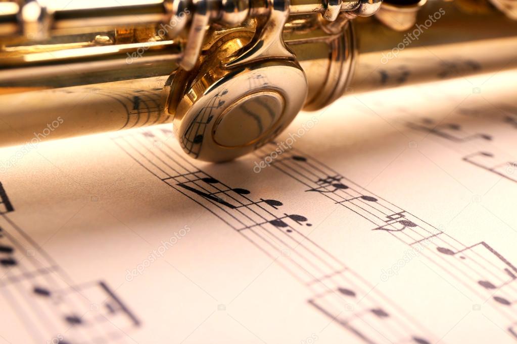Silver flute on music notes background — Stock Photo © belchonock #77030503