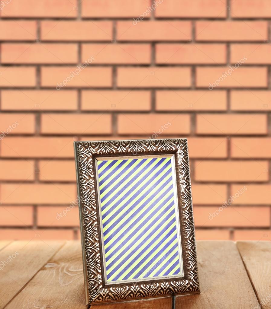 Photo frame standing on table on brick wall background — Stock Photo ...