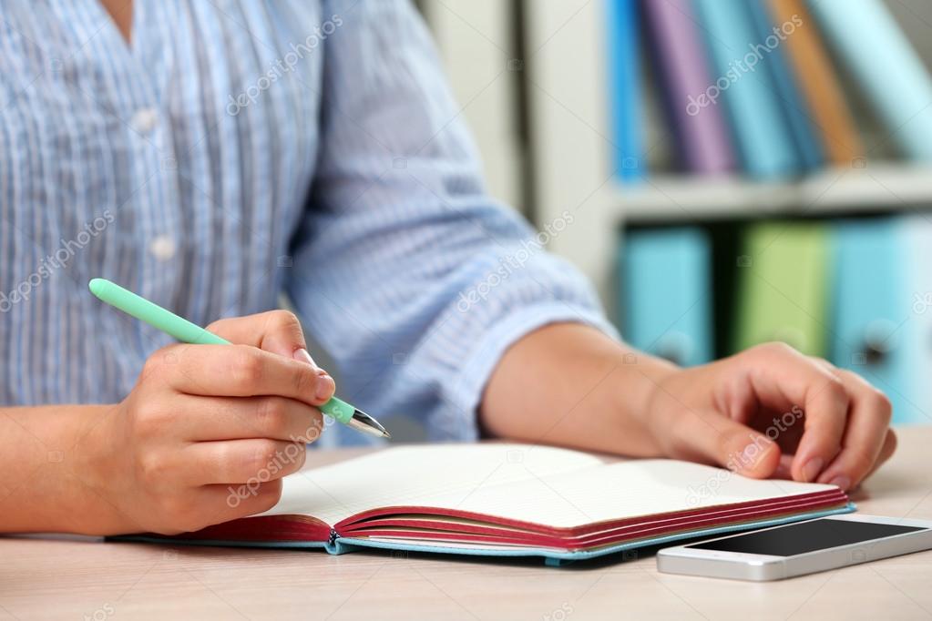 Woman write on notebook on workplace close up — Stock Photo ...
