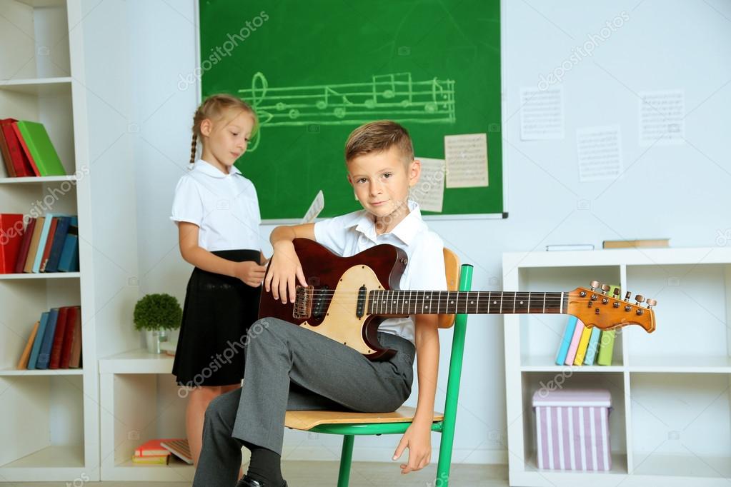 Cute pupils having music lesson Stock Photo by ©belchonock 84395728