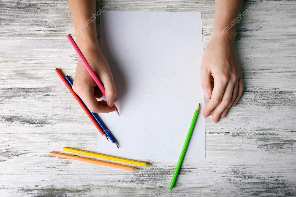 Hand with color pencils and paper Stock Photo by ©belchonock 86376030