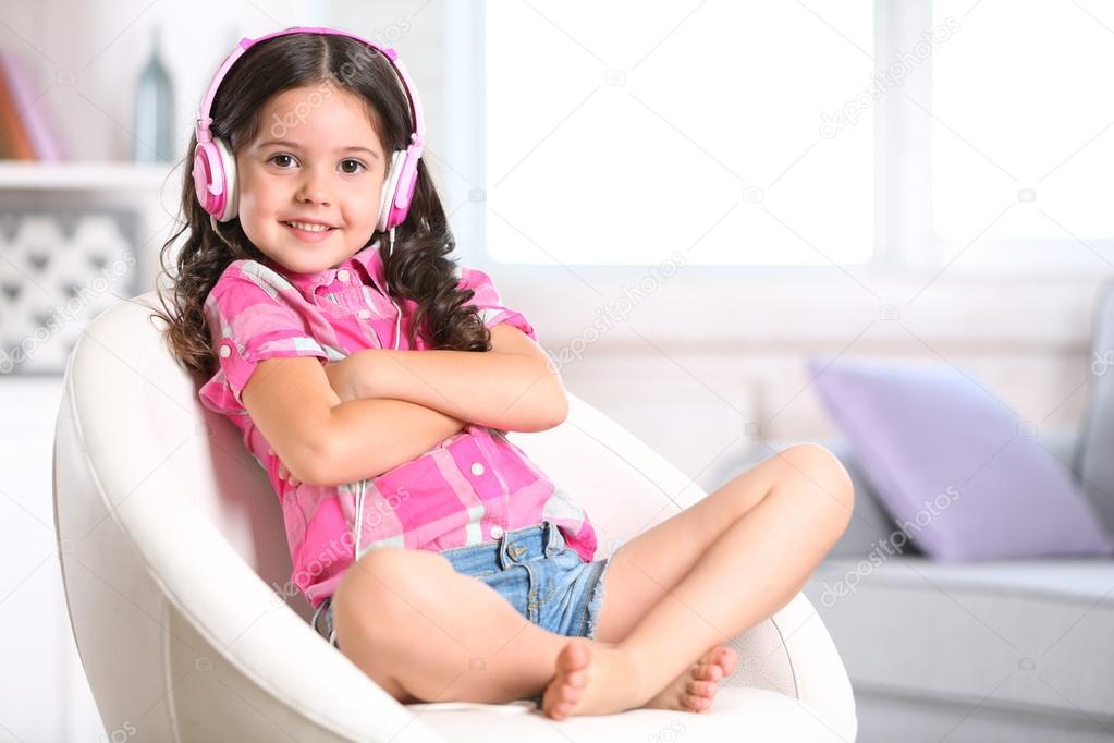Attractive little girl sitting on chair — Stock Photo © belchonock #89561604