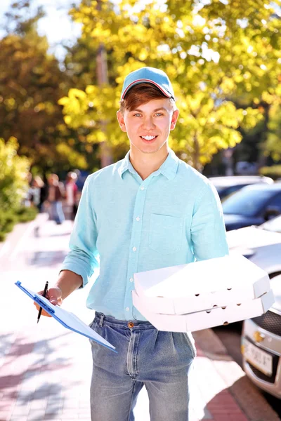 Delivery boy with pizza boxes Stock Photo by ©belchonock 94342652