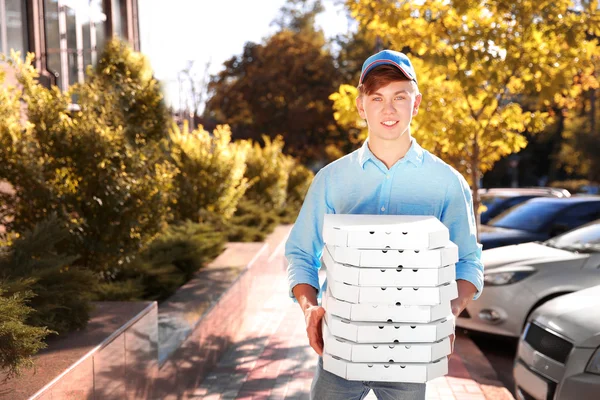 Delivery boy with pizza boxes Stock Photo by ©belchonock 94342652