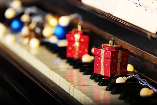 Christmas decorations on piano keys — Stock Photo © belchonock #120328838