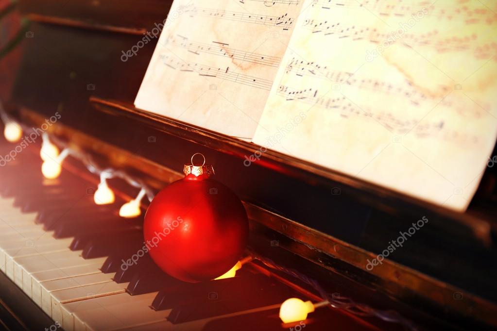 Piano keys decorated with decoration lights and red ball, close up ...