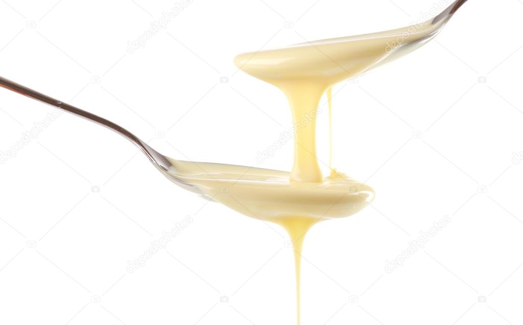 Condensed milk pouring from spoons, isolated on white Stock Photo by ...