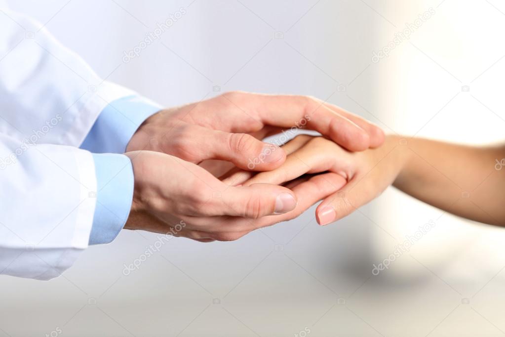 Doctor holding patient hands Stock Photo by ©belchonock 98259630
