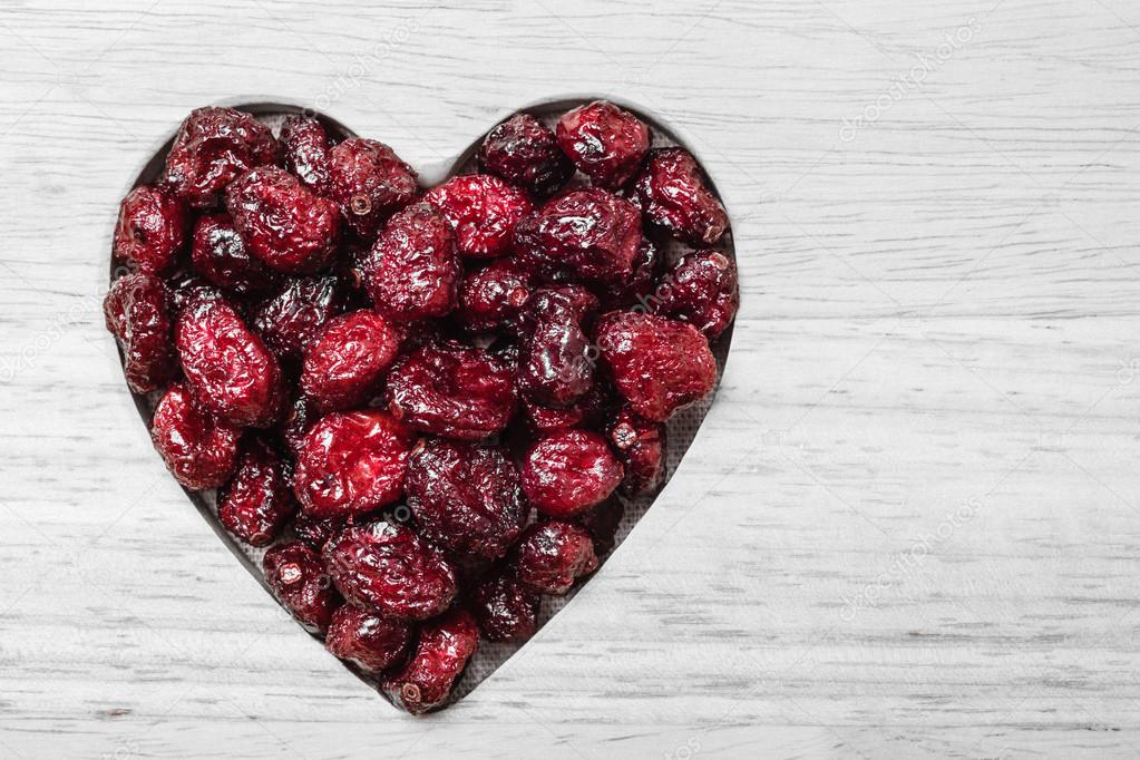 Dried cranberry fruit heart shaped on wood board — Stock Photo ...