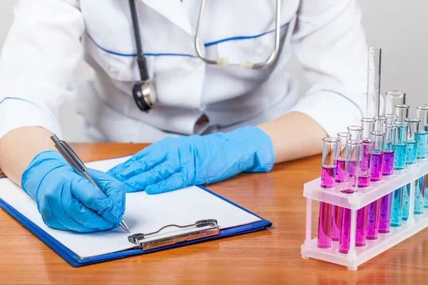 Doctor write beside test tubes standing - Stock Image - Everypixel