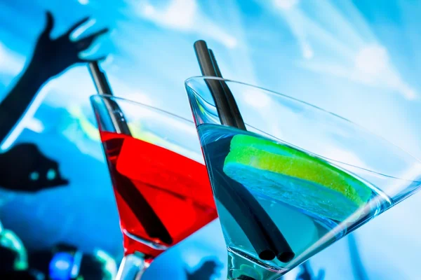 Red and blue cocktail on light disco background with space for text ...