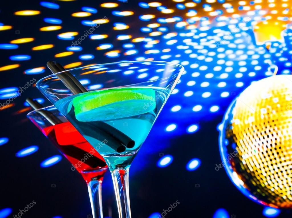 Blue and red cocktail with golden sparkling disco ball background with ...