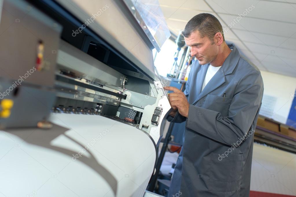 Man setting up printing machine Stock Photo by ©photography33 100333704