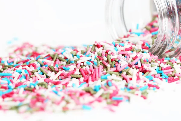 Spilled sprinkles with container on white background - Stock Image ...
