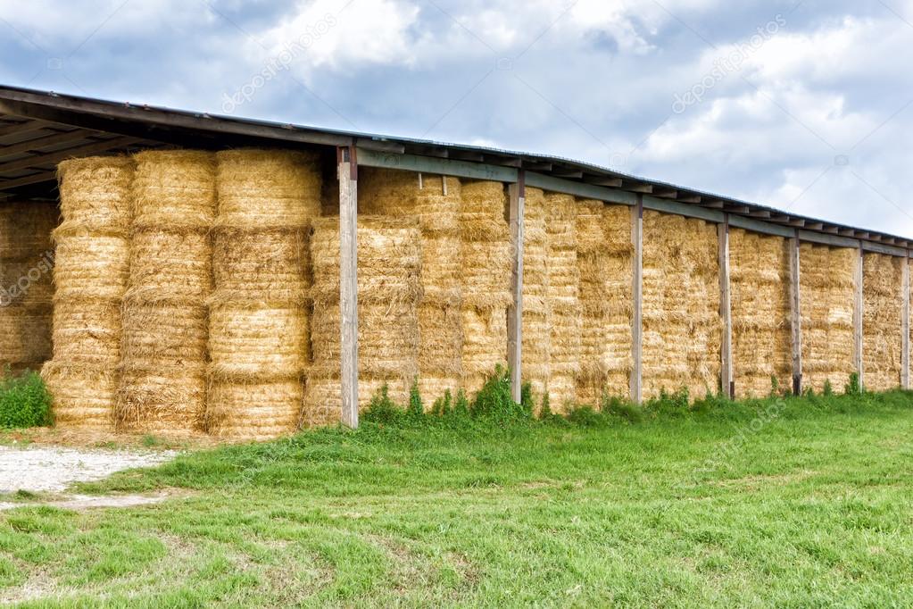 Hay bale stacked in barn Stock Photo by ©ilfede 51911729