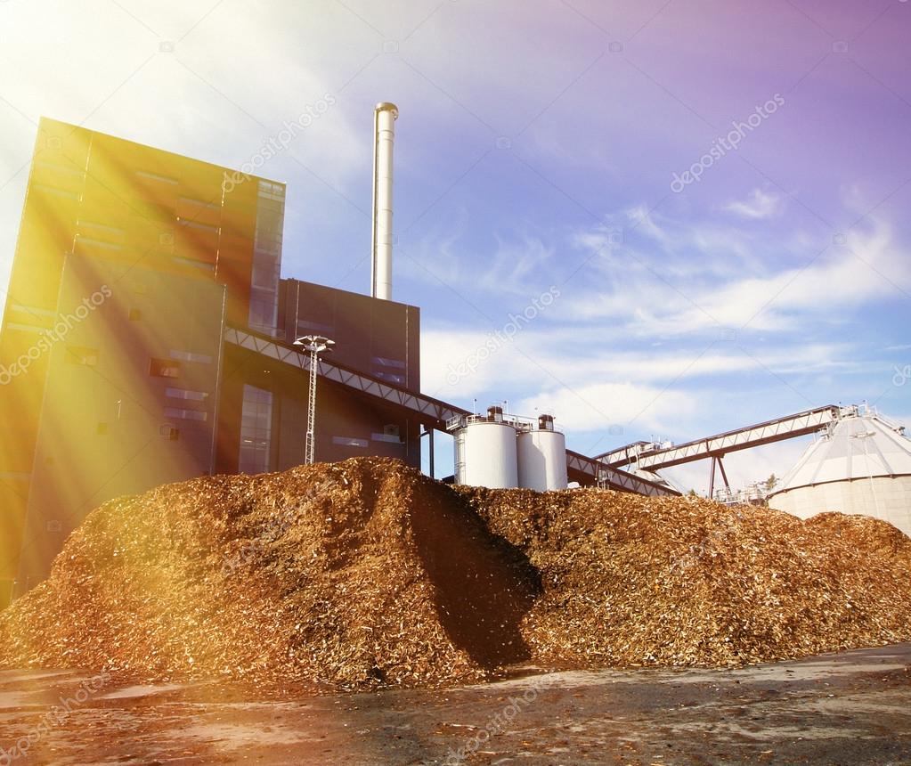 Bio power plant with storage of wooden fuel against blue sky — Stock ...