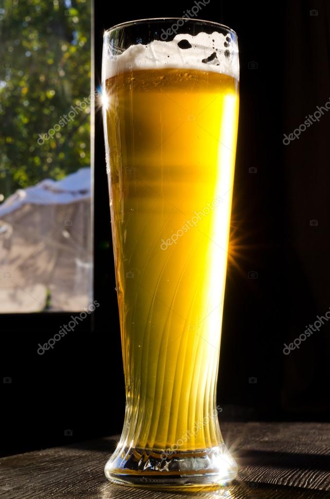 Cerveza fría en vaso largo en la mesa de madera 2023