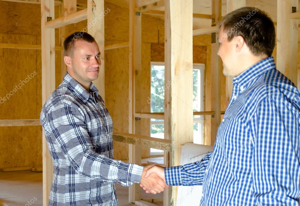 Two men shaking hands in a new build house Stock Photo by ©ampack 59179521