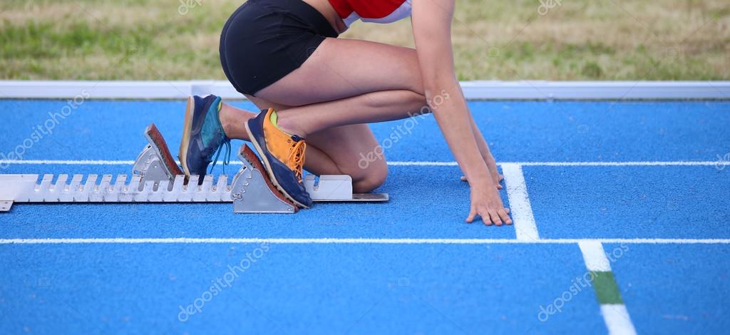 Muscular young athlete in the starting blocks of a athletic trac Stock ...