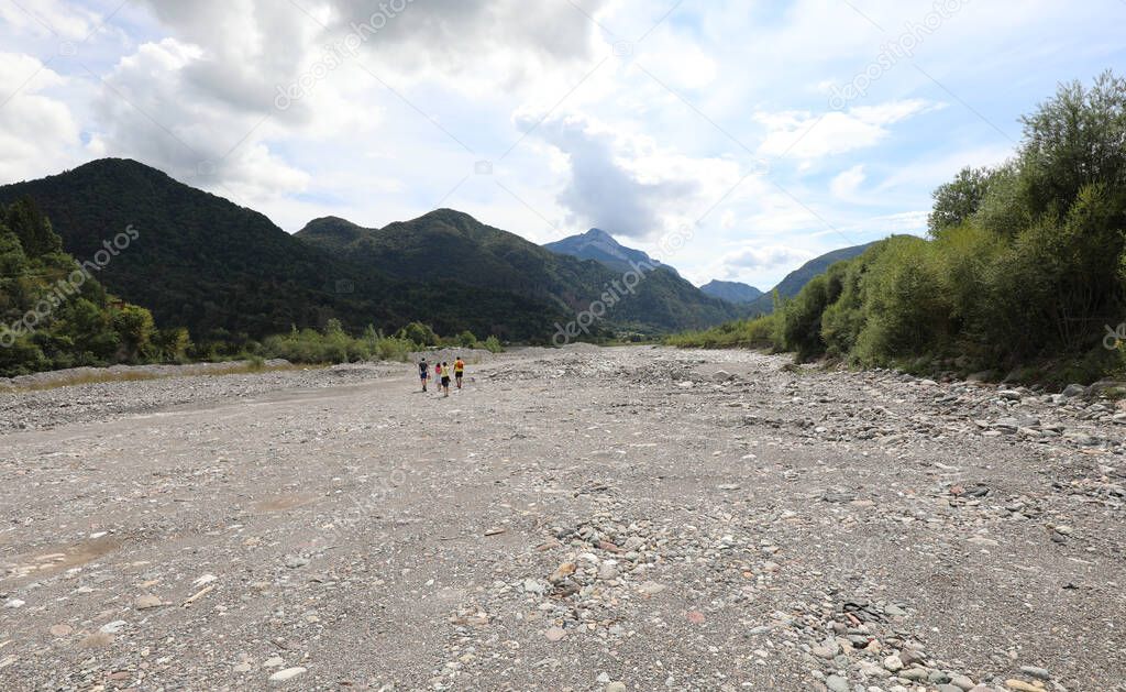 familia de cuatro caminando en el medio del lecho seco del río debido ...