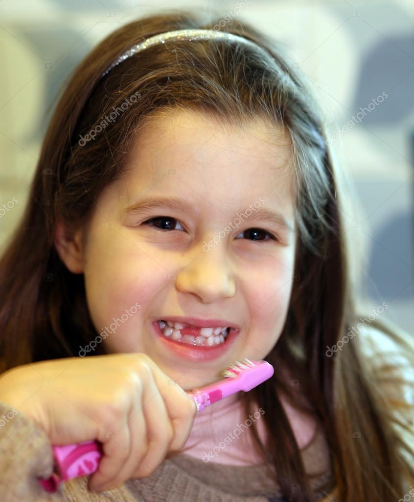 Young girl without a tooth while brushing teeth in the bathroom Stock ...