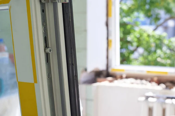 Part of the new plastic window in the foreground, installation of a ...