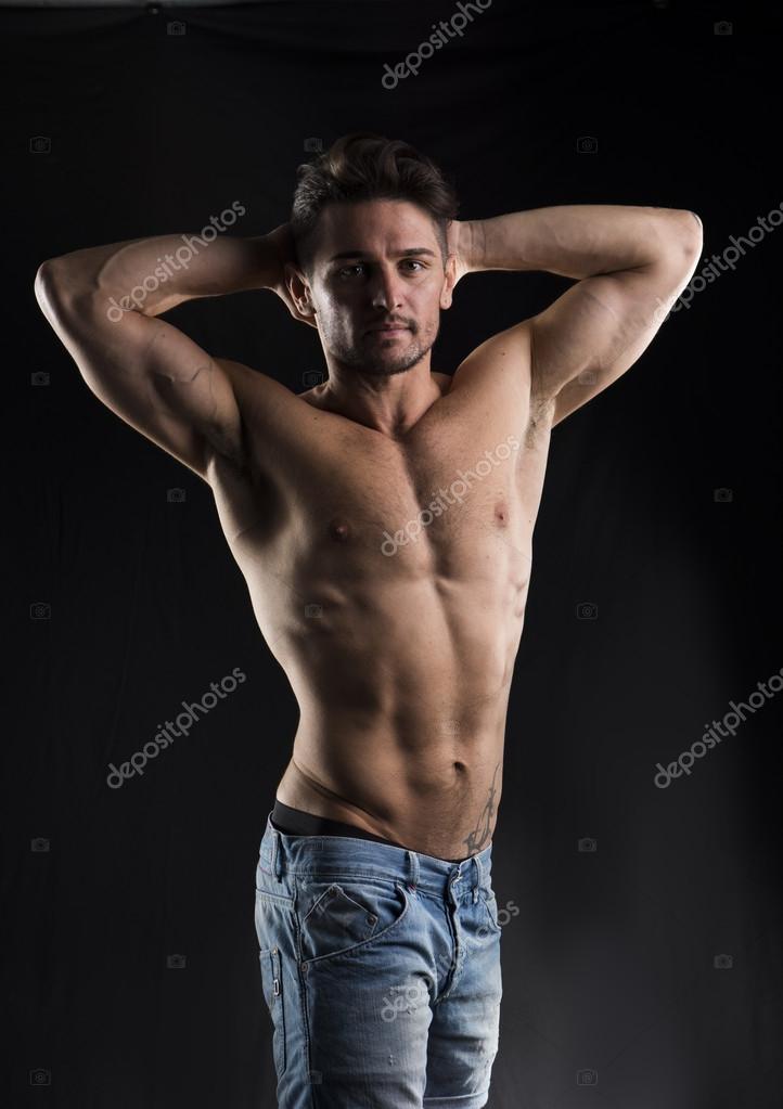 Handsome muscular shirtless young man with hands behind head ...