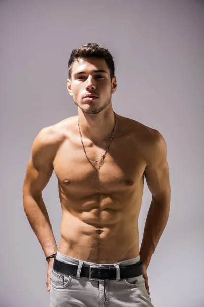 Handsome, fit shirtless young man in jeans isolated on black Stock ...