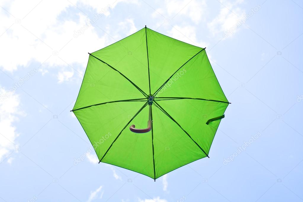 Green umbrella flying on a blue sky Stock Photo by ©domnitsky.yar 113516864