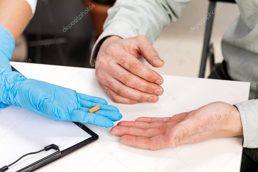 El dermatólogo examina la piel del paciente que tiene en sus manos una ...