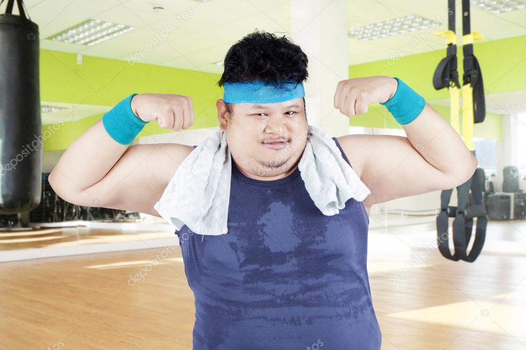 Fat man showing his arm bicep — Stock Photo © realinemedia #53784493
