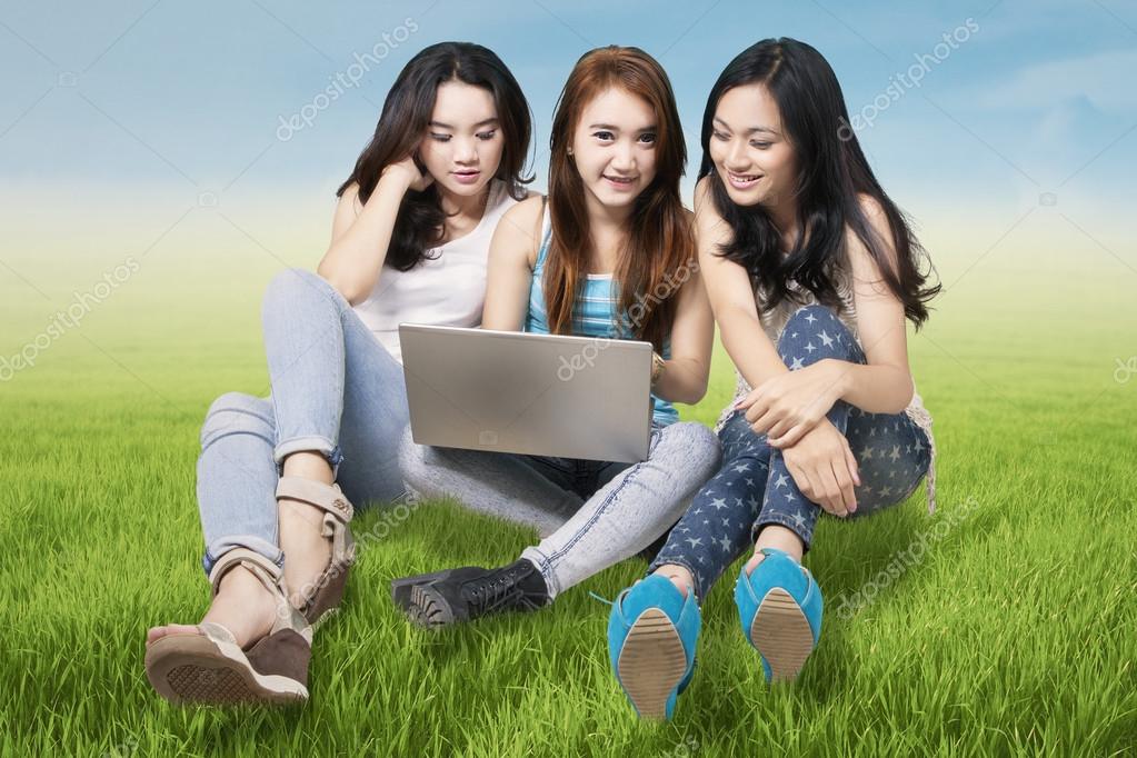 Three students with laptop in nature Stock Photo by ©realinemedia 72904493