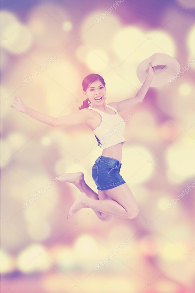 Woman with hat jumping over blur background — Stock Photo ...