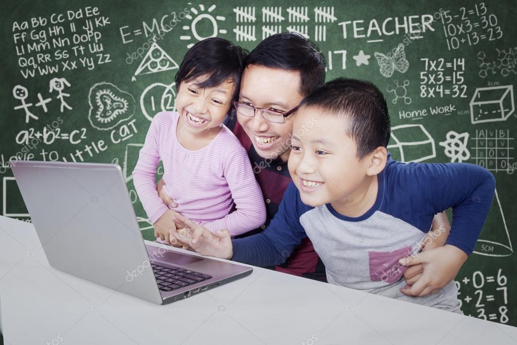 Kids and teacher having fun with laptop in class — Stock Photo ...