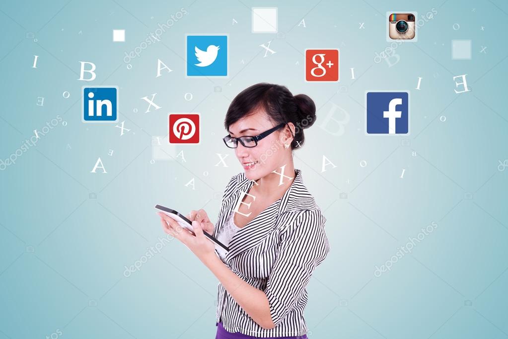 Young woman using tablet with social media icons — Stock Editorial ...