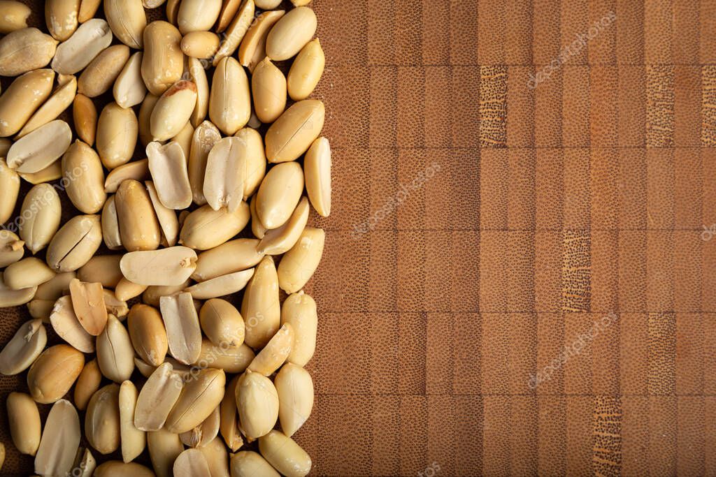 vista superior de semillas de cacahuete peladas cerrar sobre fondo de madera de bambú para ...