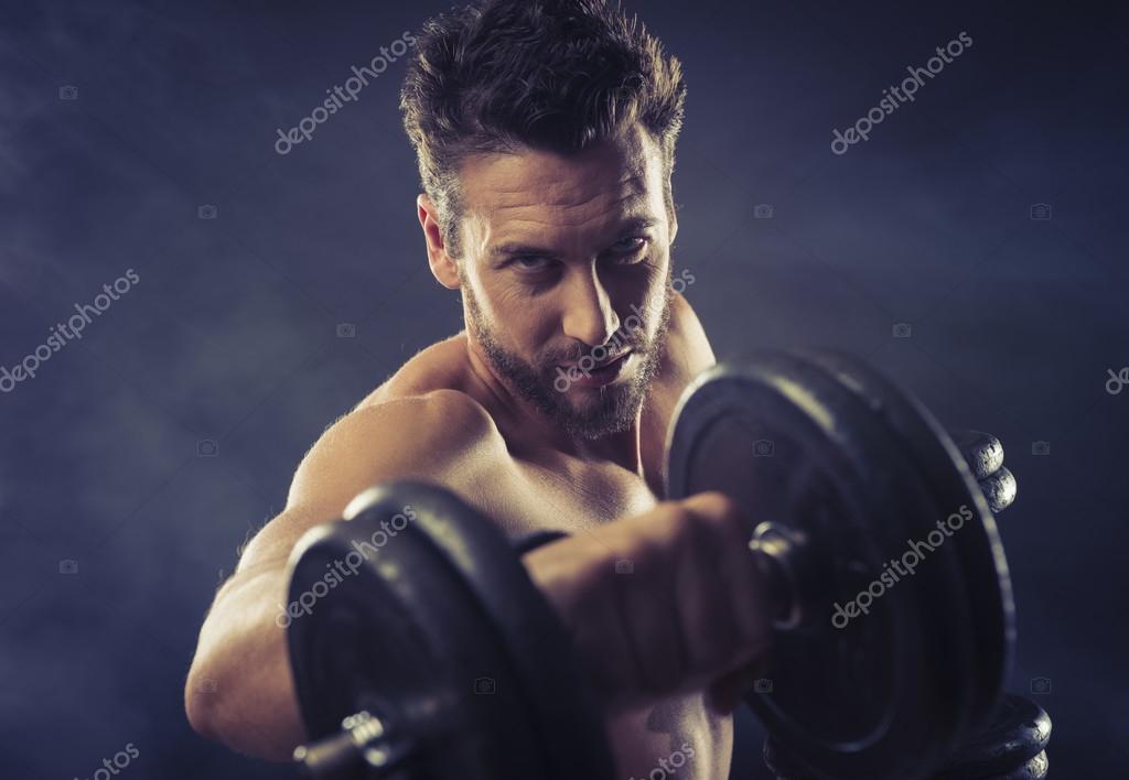 Attractive man weightlifting Stock Photo by ©stokkete 62759103