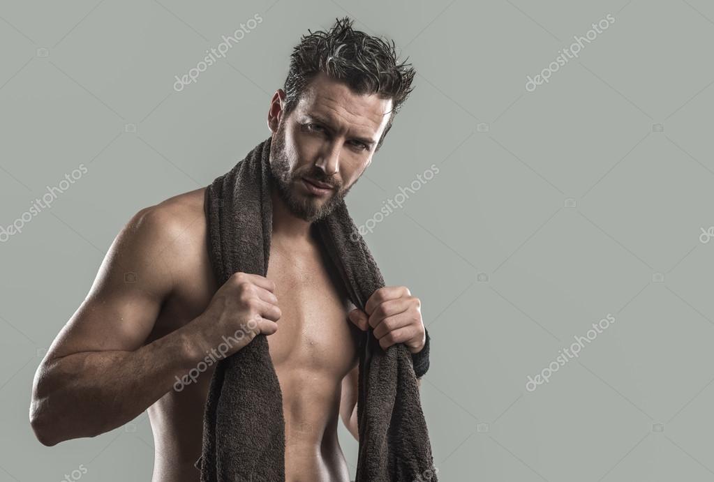 Muscular man drying athletic body Stock Photo by ©stokkete 63435009