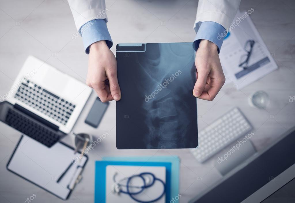 Radiologist checking an x-ray image Stock Photo by ©stokkete 70655389